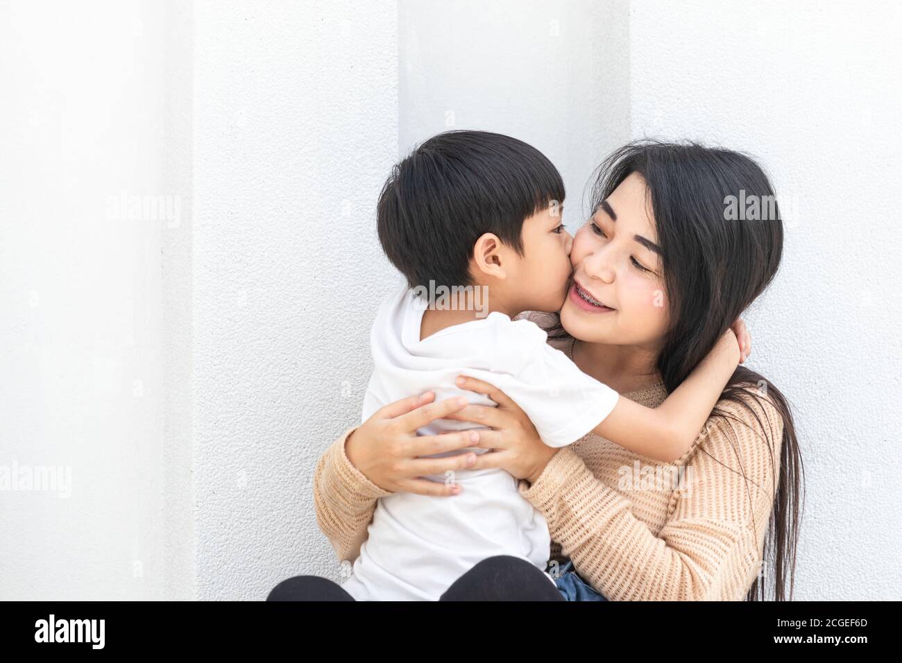 Mother and child happily hugged and kissed each other's cheeks. Asian ...