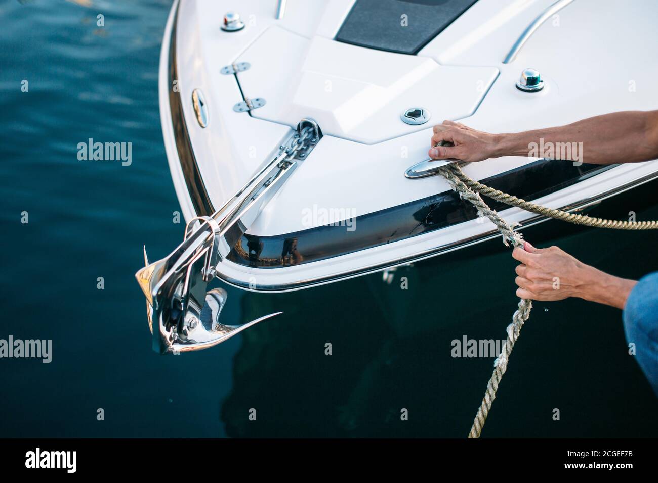 Man s hand with boat rope. Yachtsman moors his motor boat at jetty ...