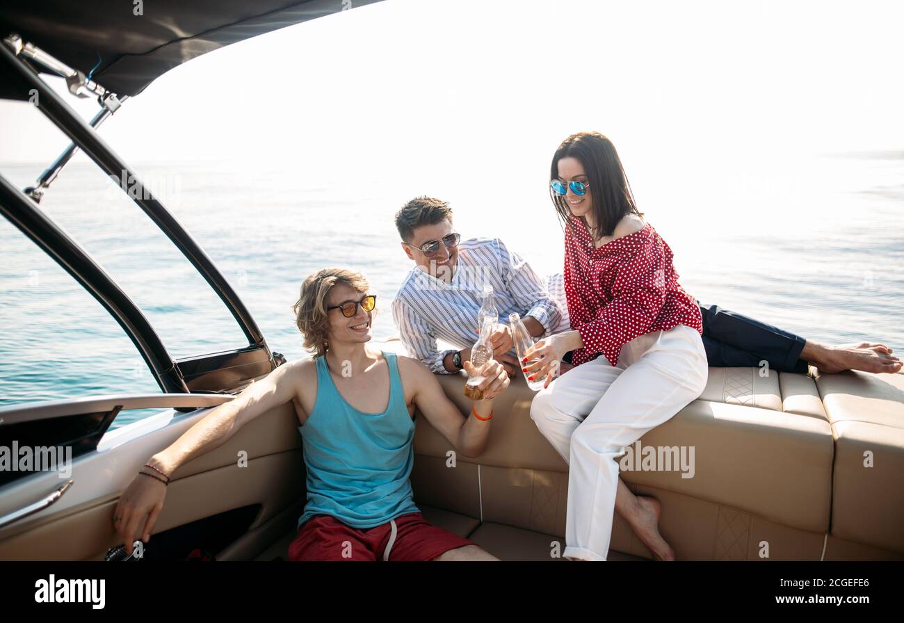 friends making boat party having fun drinking beers and laughing ...