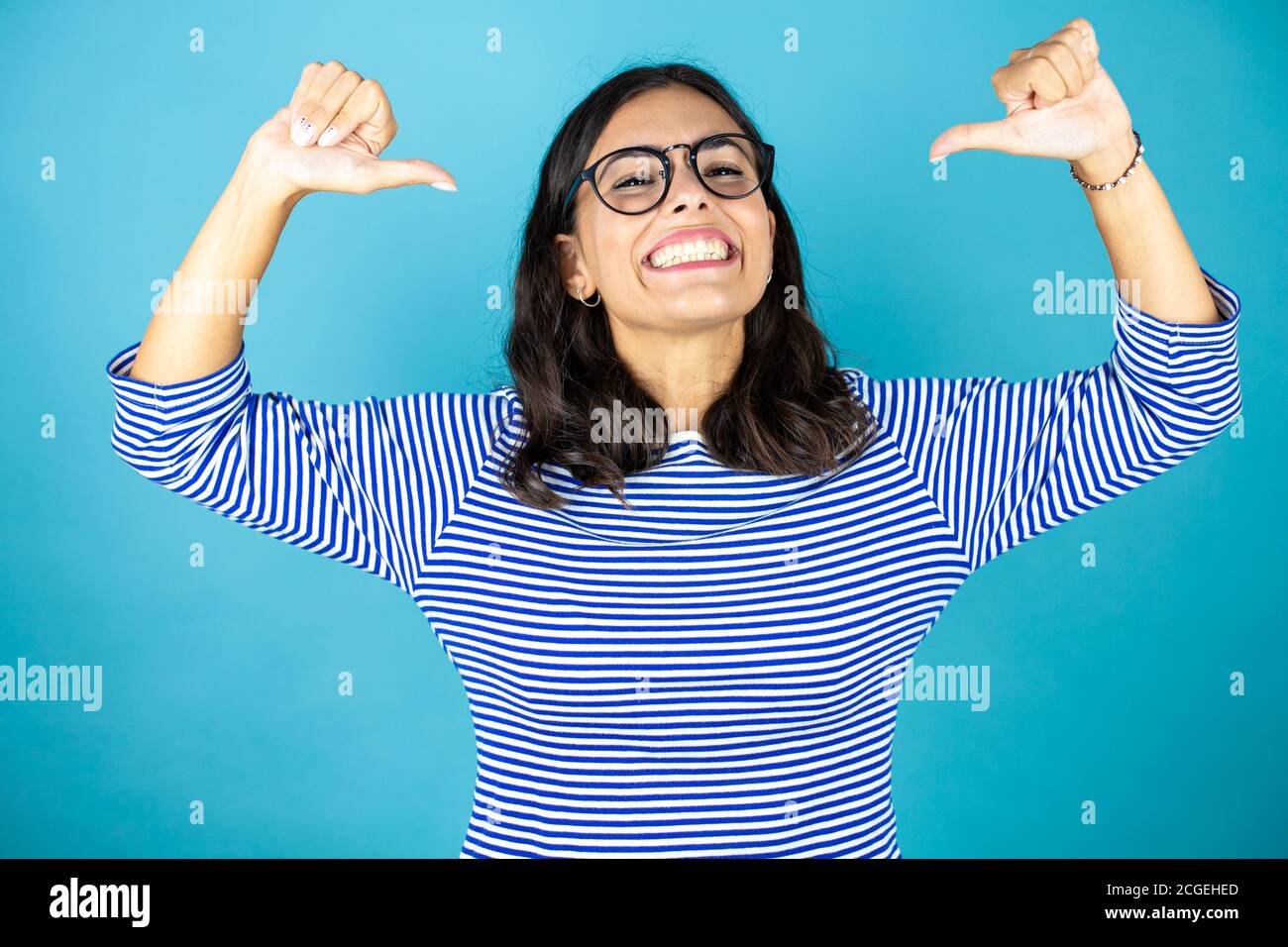 Pretty woman wearing glasses standing over insolated blue background ...