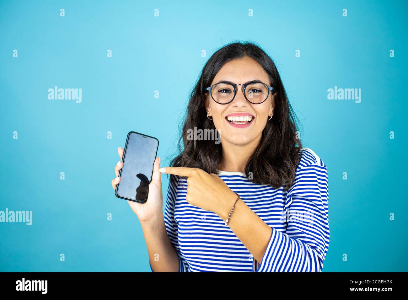 Pretty woman wearing glasses standing over insolated blue background ...