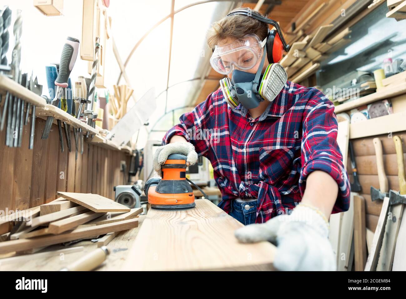 Young adult caucasian mid aged professional female carpenter grinding ...
