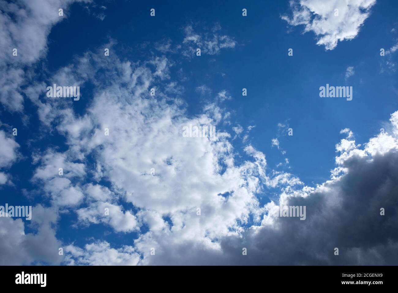 white clouds against the blue sky. bright sun behind clouds bottom view ...