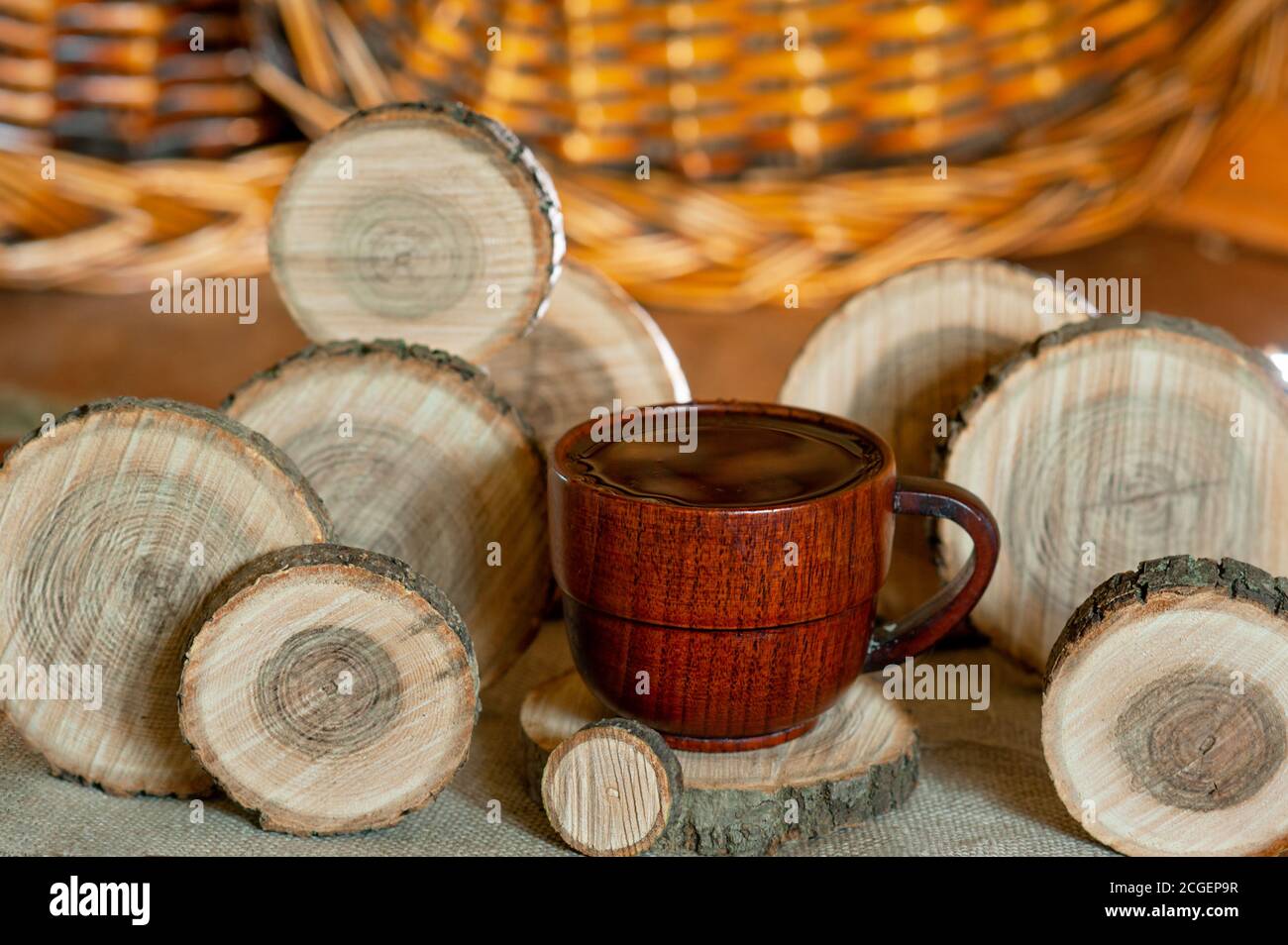 natural dark wooden cup and round wooden slices of natural wood around ...