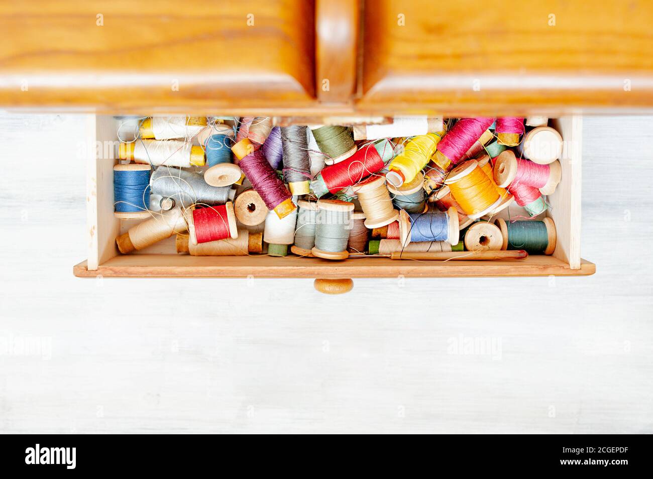 lots of colorful balls of thread in wooden box, tools for sewing hobby ...