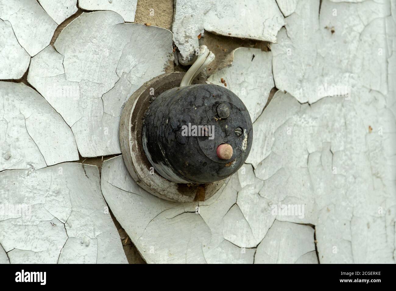 Black vintage light switch on the old wall with cracked white paint ...