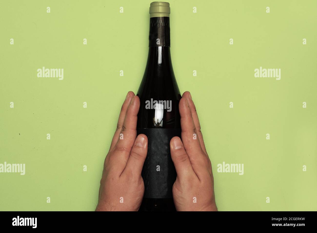Man hands grabbing a bottle of wine on green background. flat lay flat ...