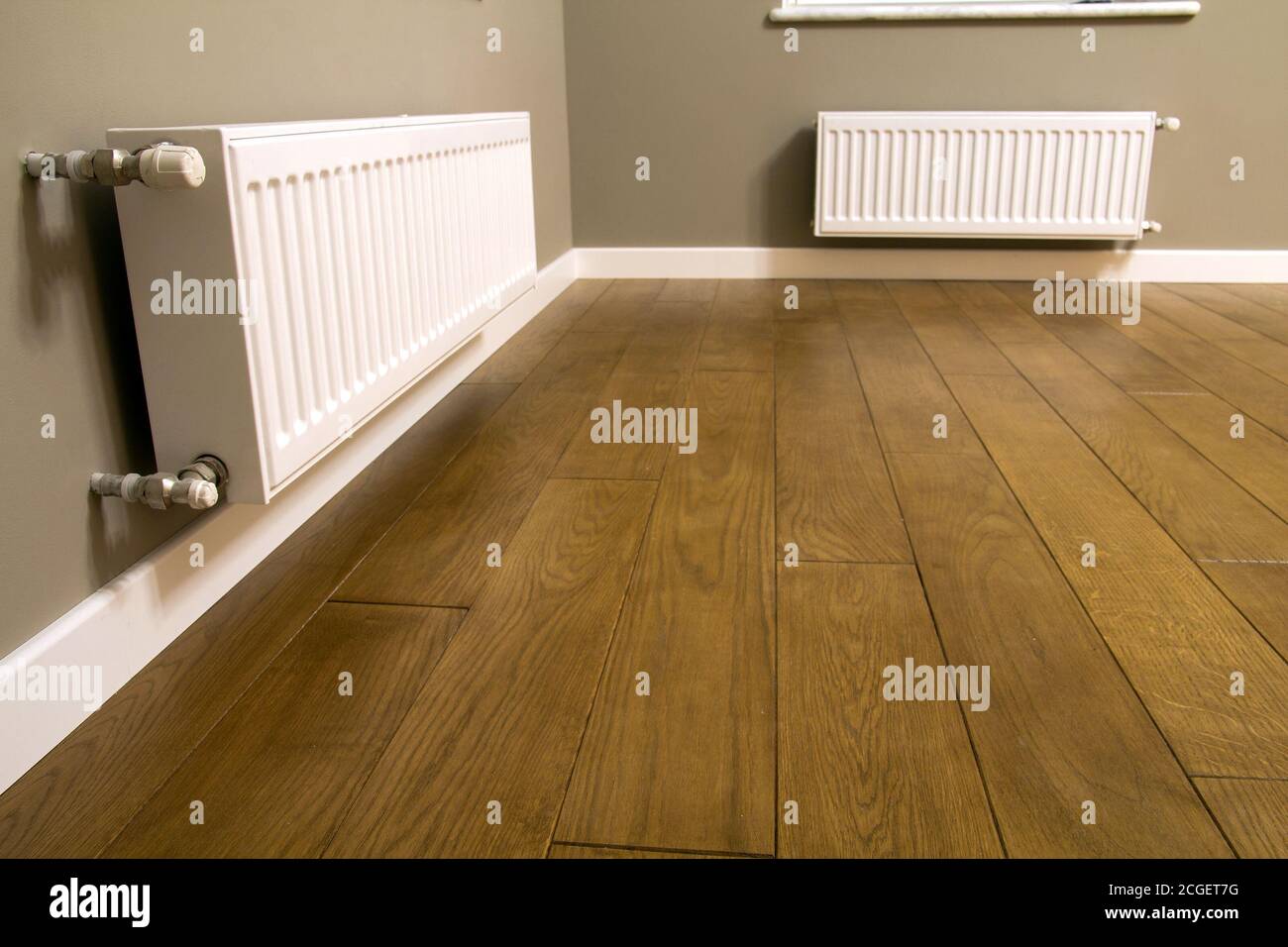 White metal heating radiator mounted on gray wall inside a room Stock ...