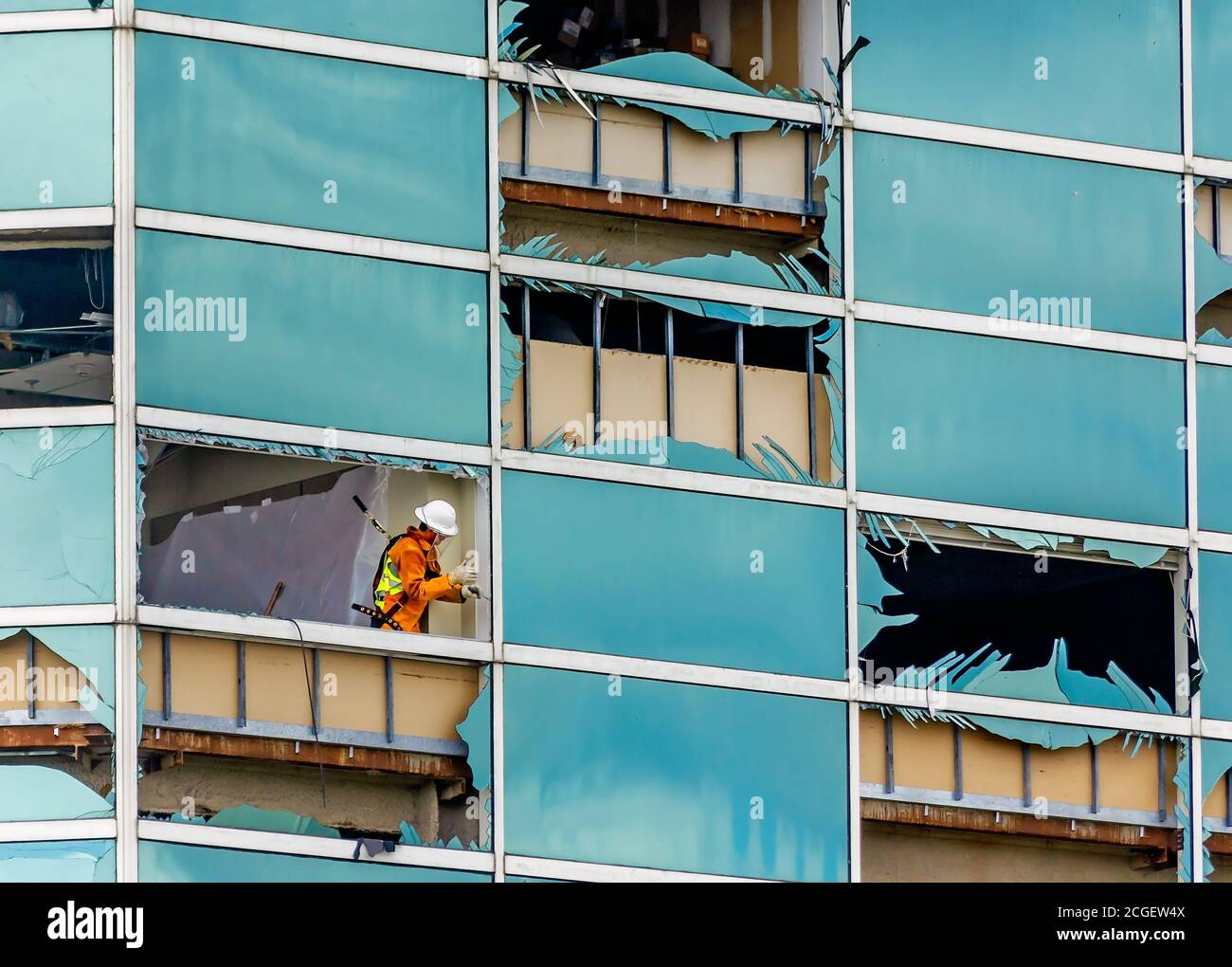 A worker removes the shattered glass from a window at the Capital One ...