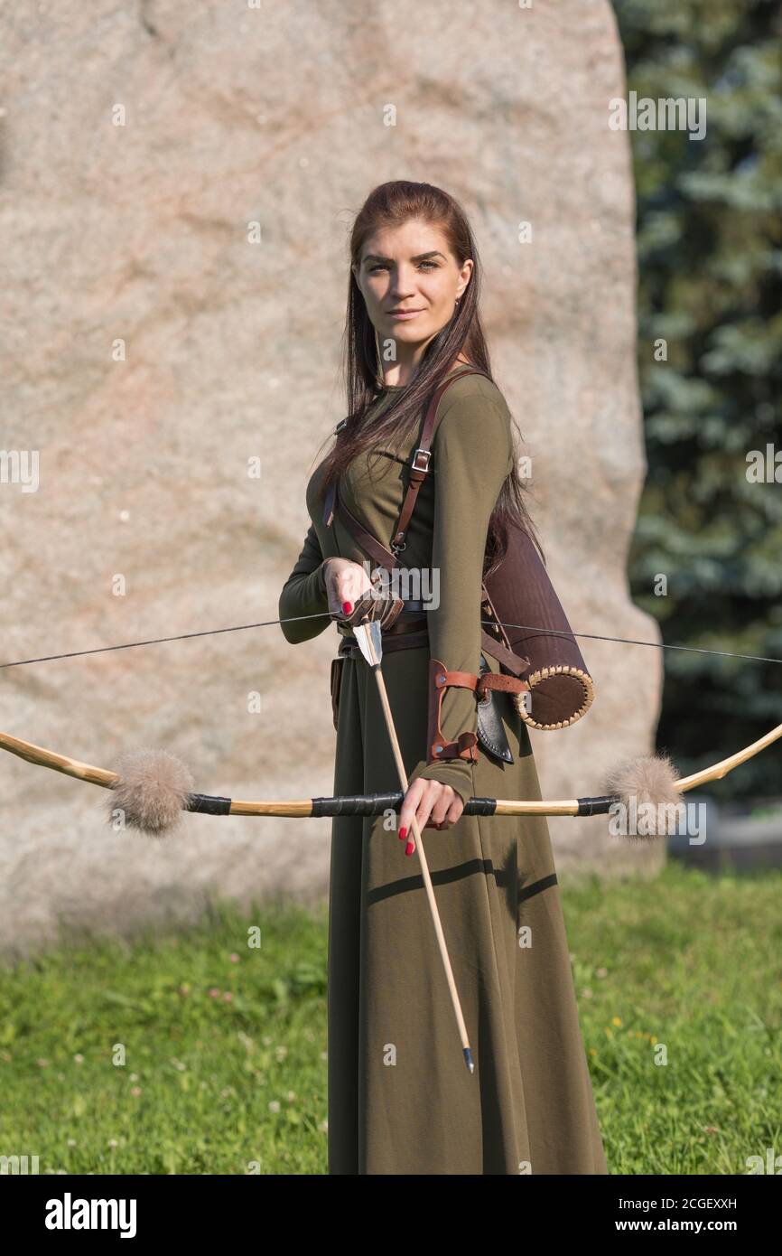 Close-up woman with bow and arrow in forest arrow costume Stock Photo ...