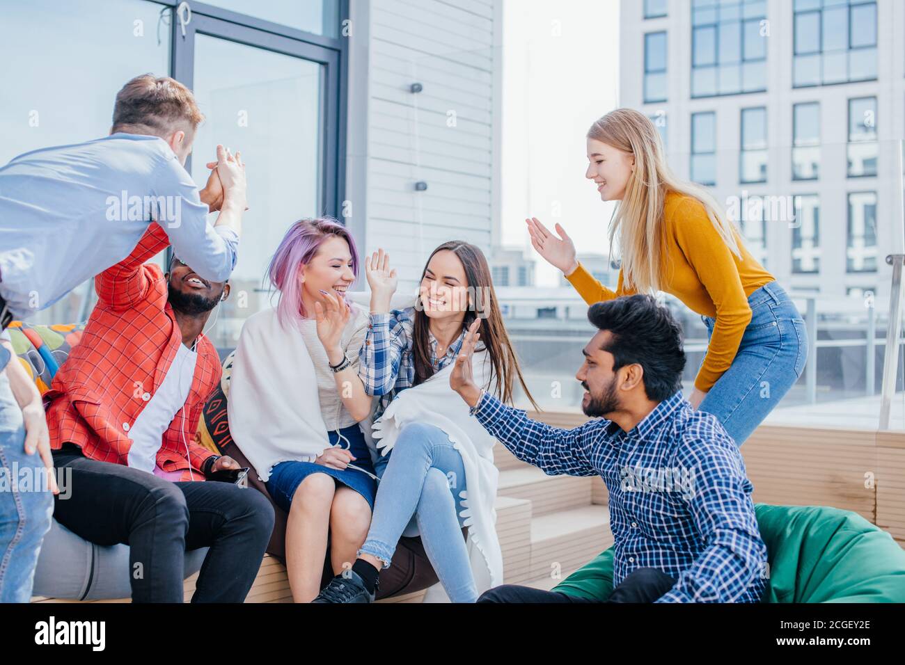 Excited creative group of multiethnic designers giving high-five in ...