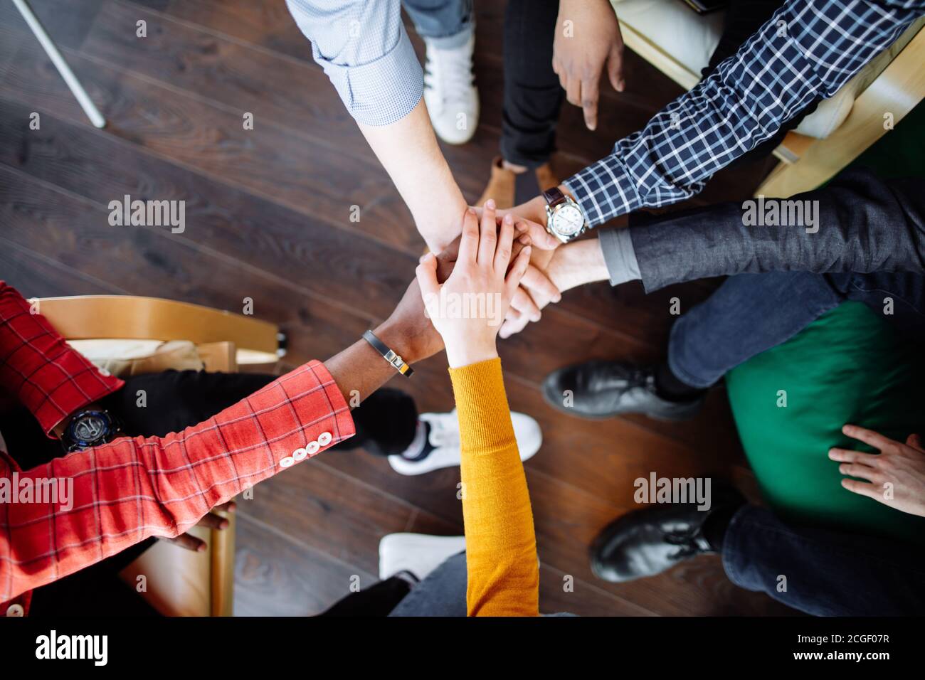 Multiracial cheerful colleagues, business men and woman give high five together to celebrate ...