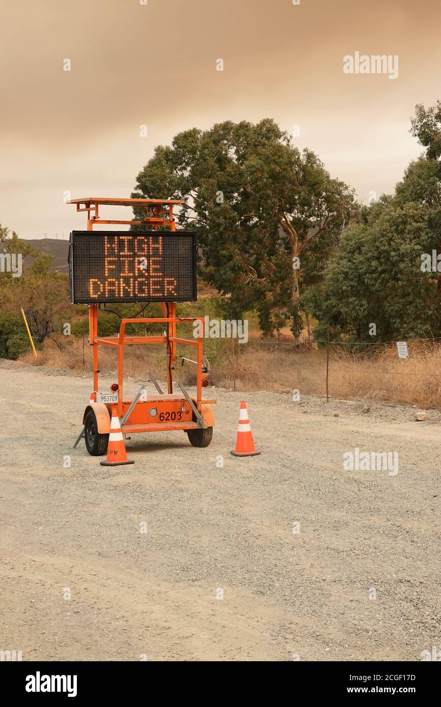 Smoke clouds behind high fire danger warning signs in California Stock ...
