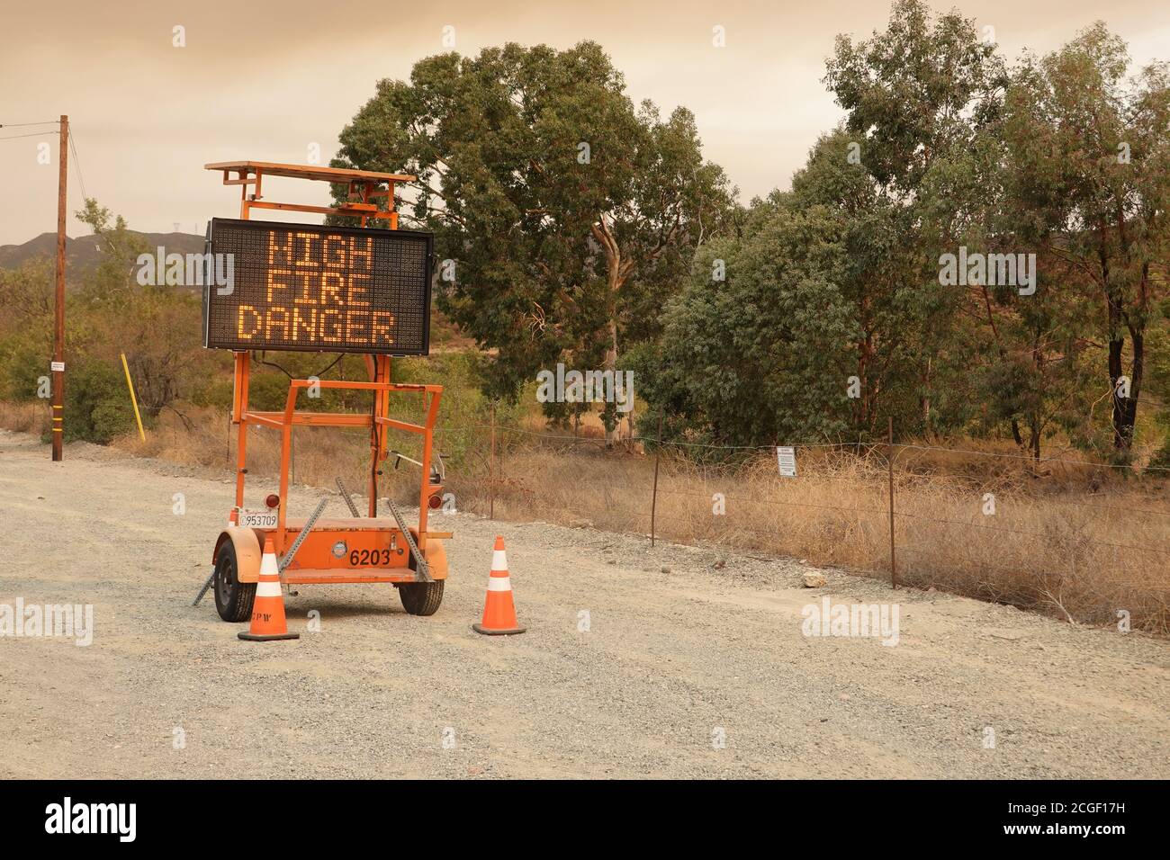 Smoke clouds behind high fire danger warning signs in California Stock ...