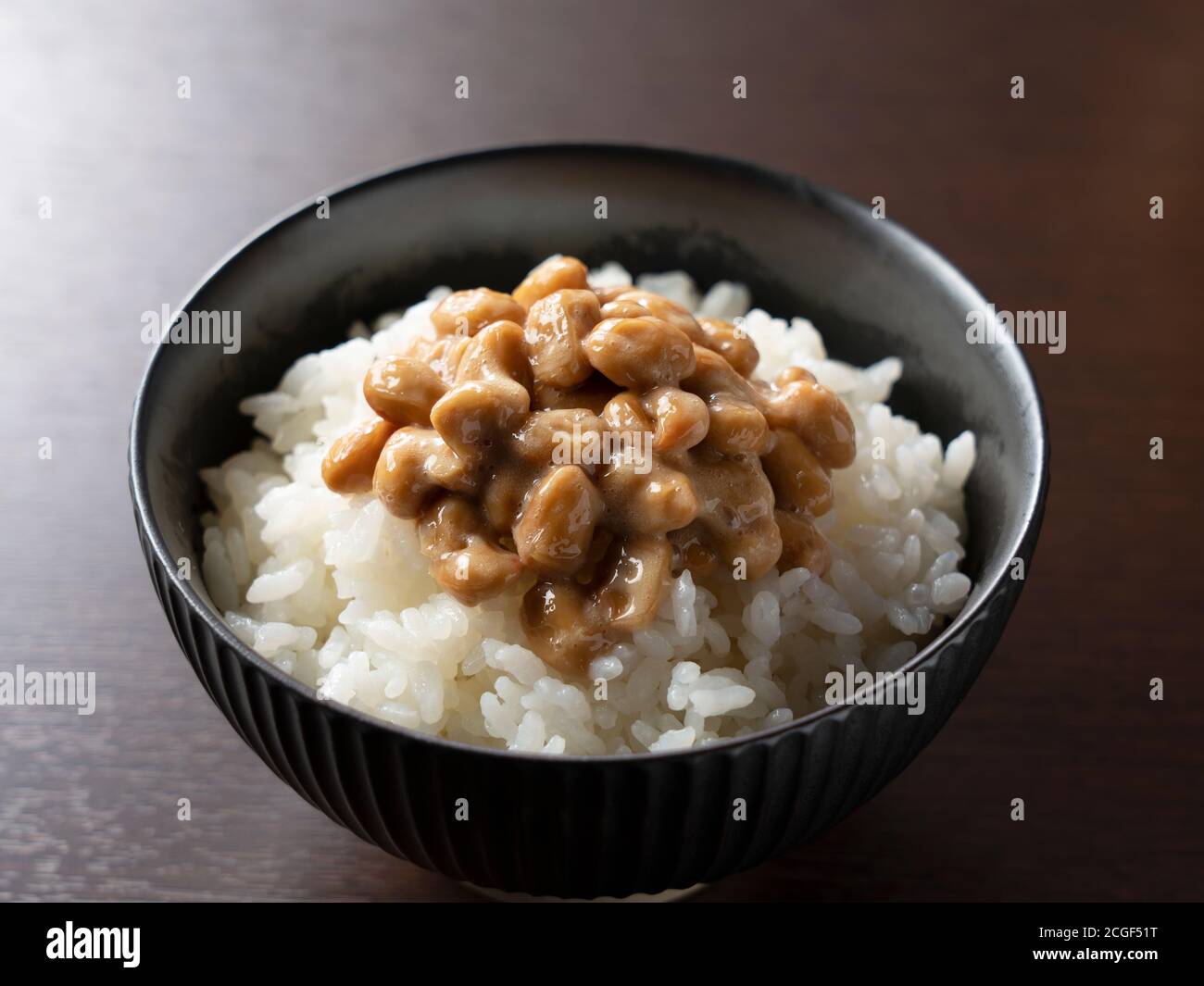 The natto put on the rice put on the background of the dark tree. Image ...