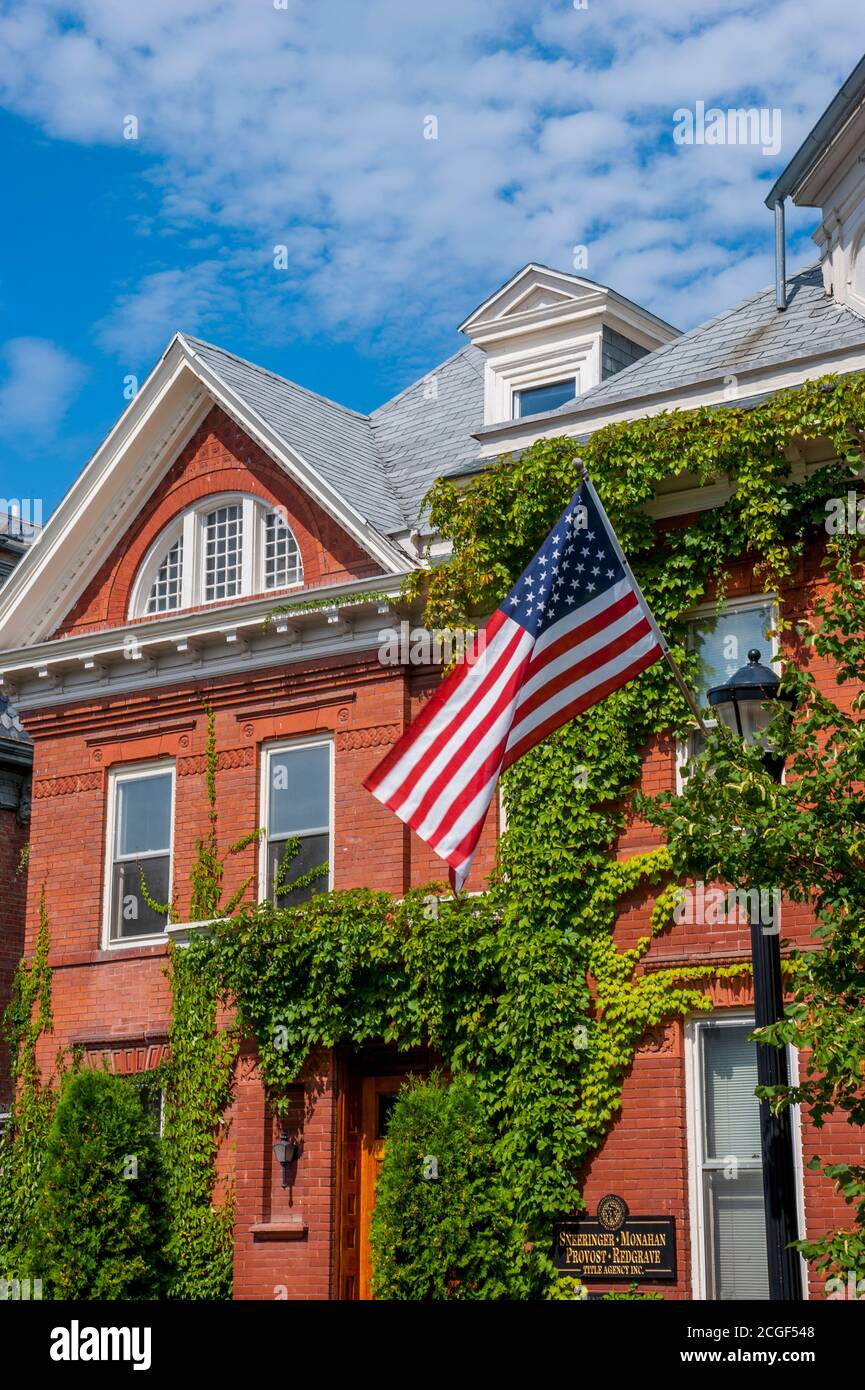 A brick house and an American flag on Warren Street in the town of ...