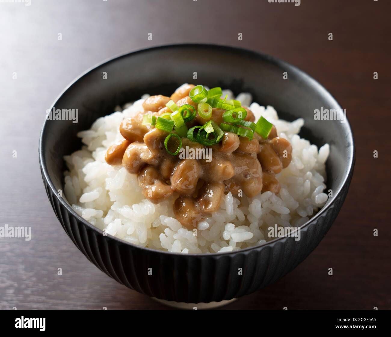 The natto put on the rice put on the background of the dark tree. Image ...