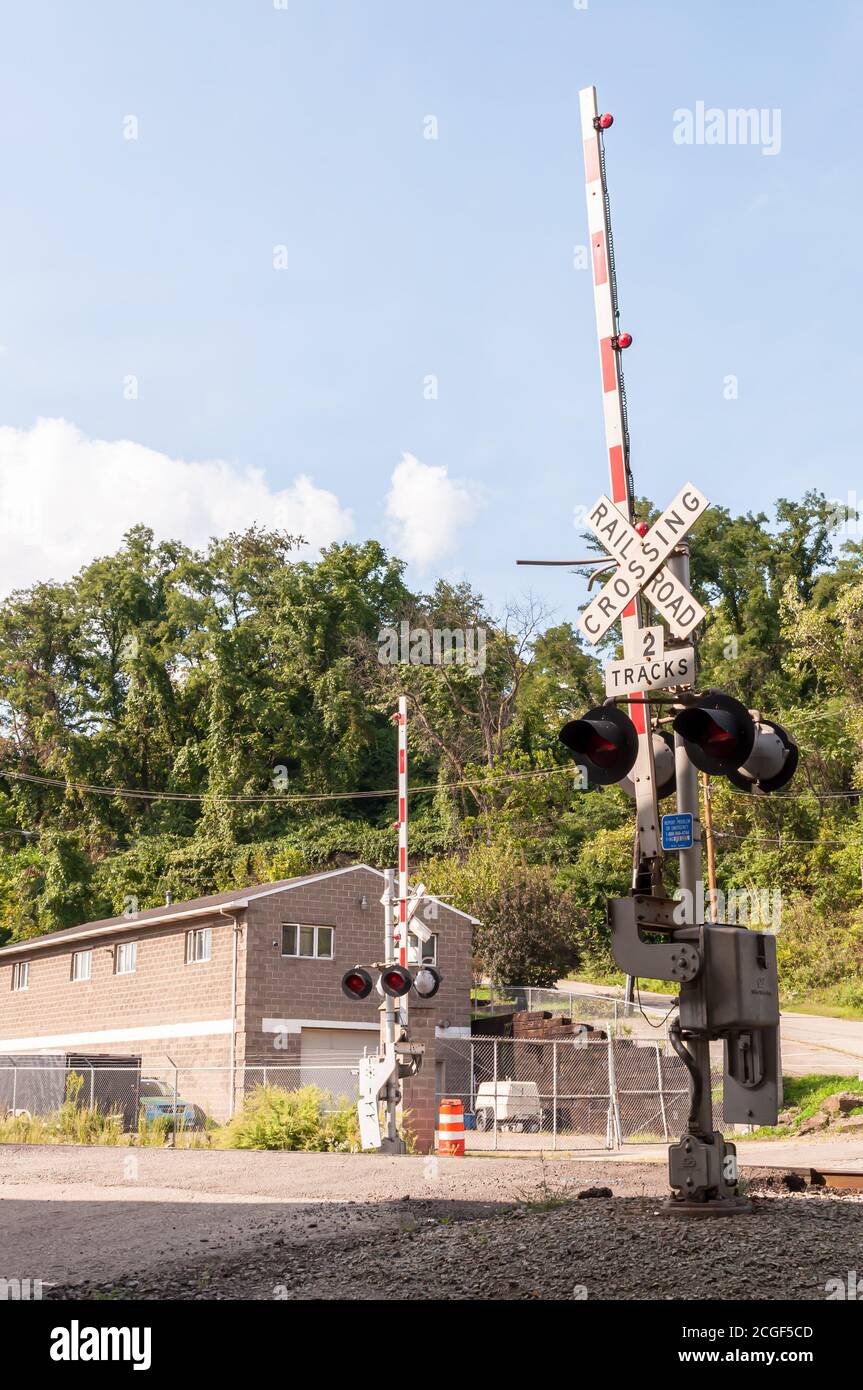 A Norfolk Southern railroad crossing at the base of a hill with a ...