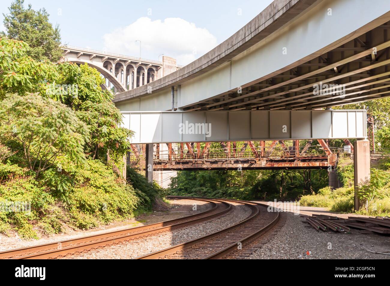 Railroad tracks under three bridges, an old rusted railroad bridge, the ...