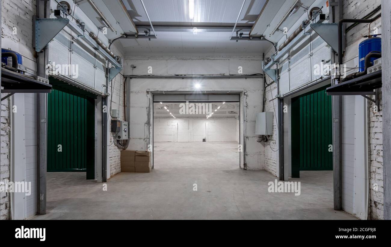 Industrial building interior with white brick walls, concrete floor and ...