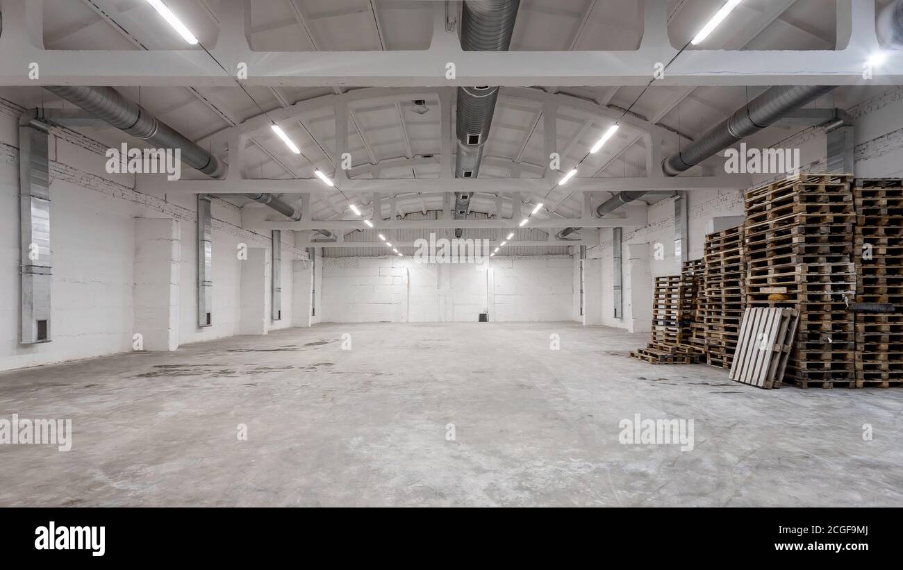 Industrial building interior with white brick walls, concrete floor and ...