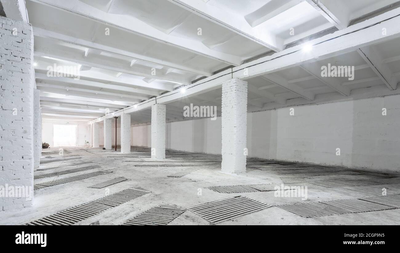 Industrial building interior with white brick walls, concrete floor and ...