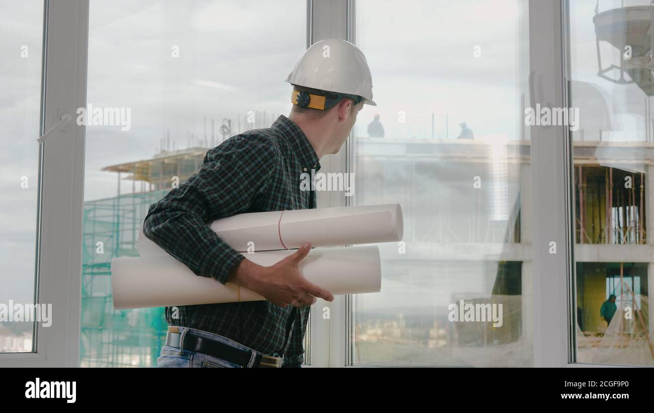 Engineer checking construction through the window Stock Photo - Alamy