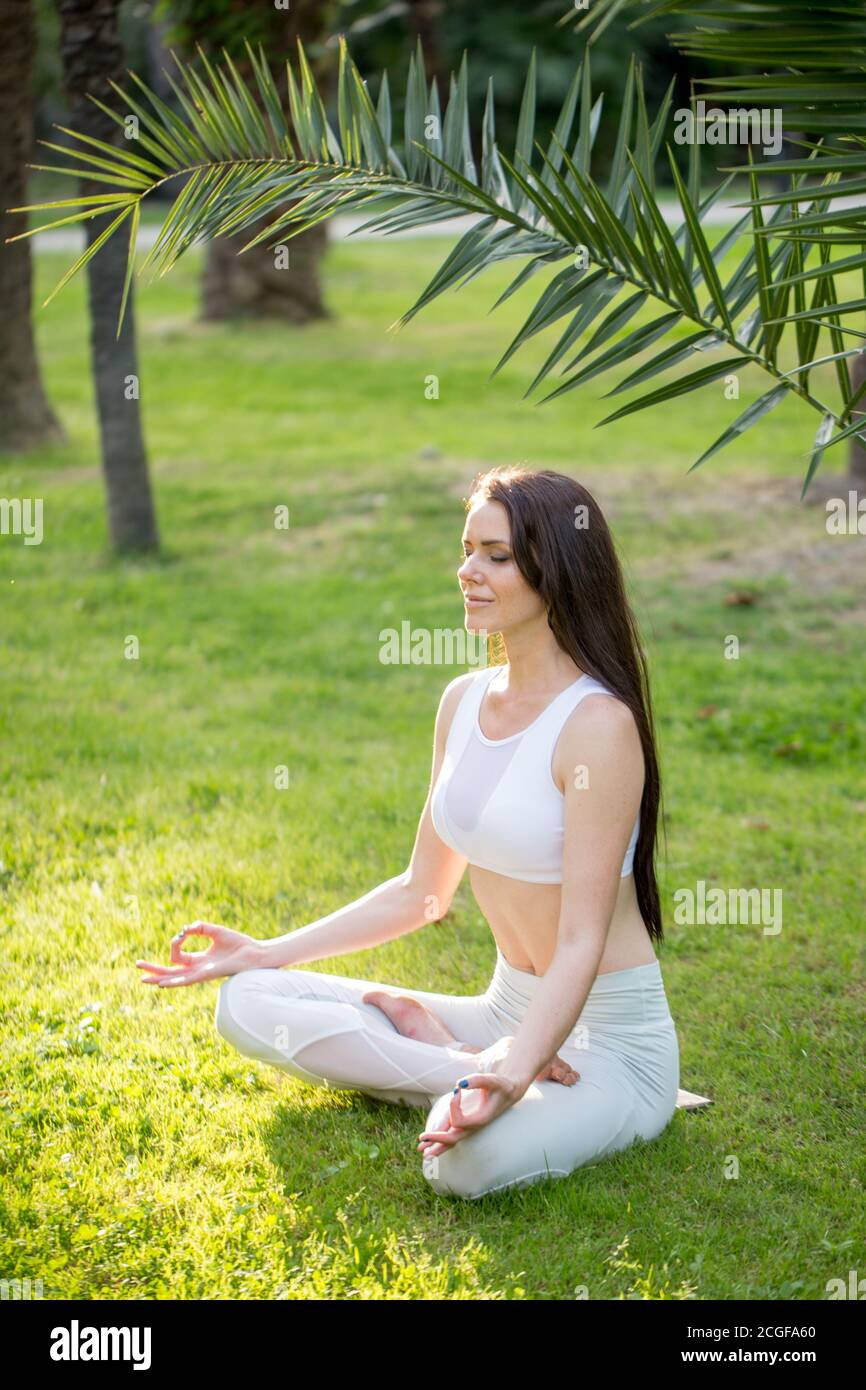 Cool attractive yogi woman practicing yoga concept, sitting in Lotus ...