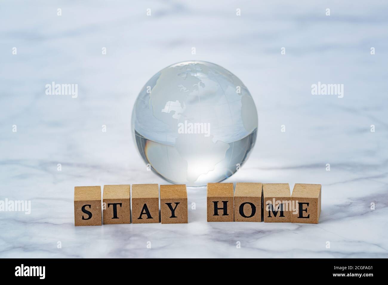 A glass globe and a block of Stay Home. Image of restraint from going ...