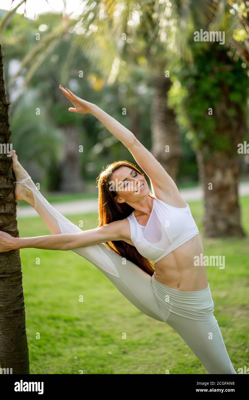 Athletic girl in wite sportswear engaging in Rhythmic Gymnastics in ...