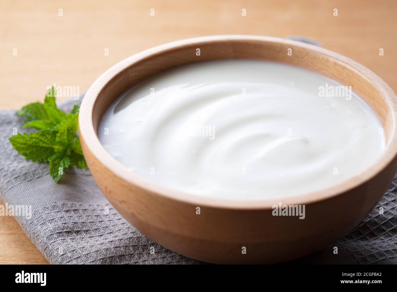 Image of yogurt in a wooden bowl Stock Photo - Alamy
