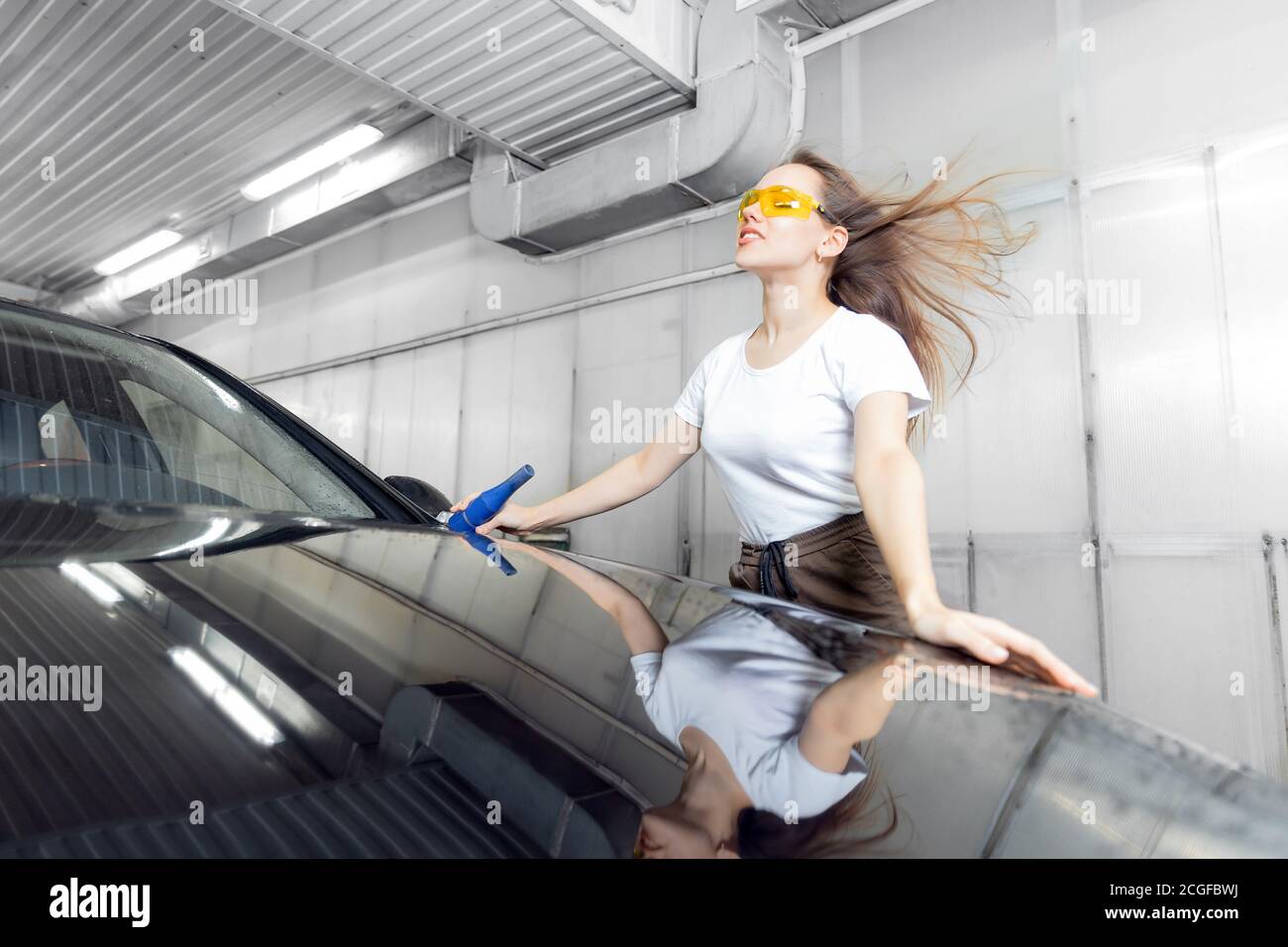 Service car wash express. Girl worker uses turbo dryer to remove drops ...