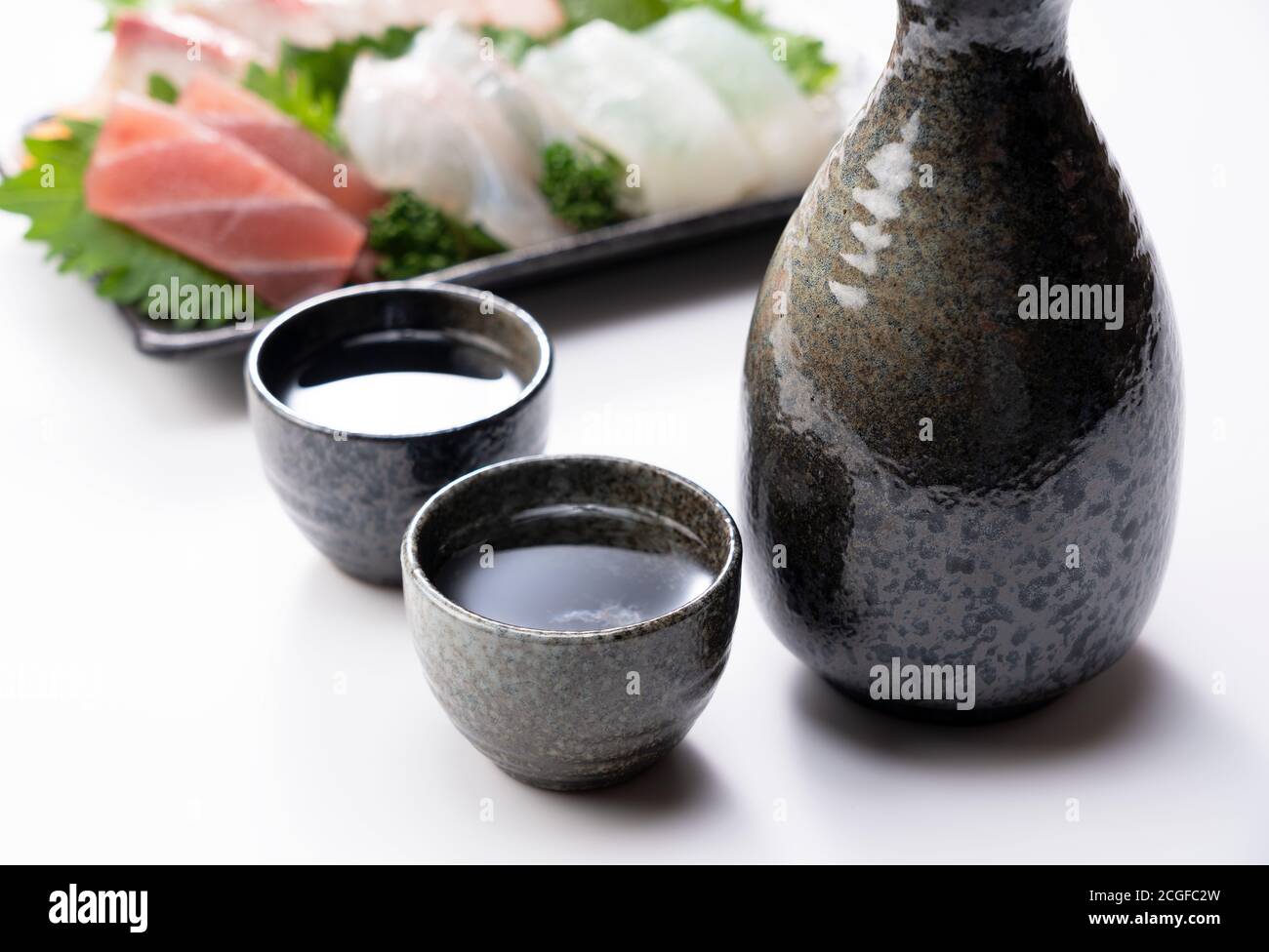 Sake and sashimi on a white background Stock Photo - Alamy