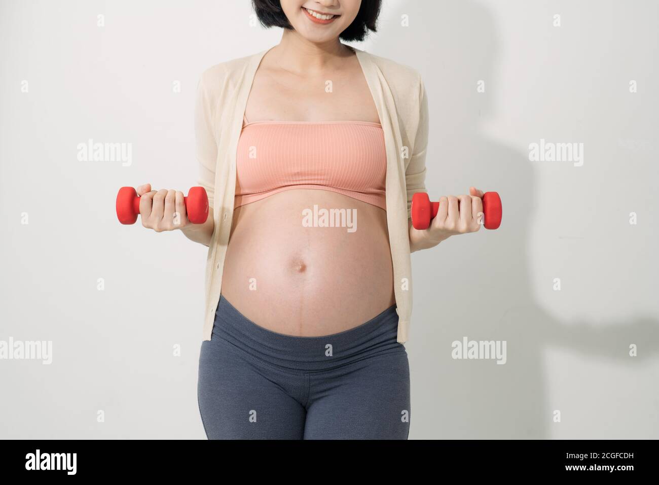 Asian Pregnant Woman Do Exercise Standing And Lifting Dumbbells