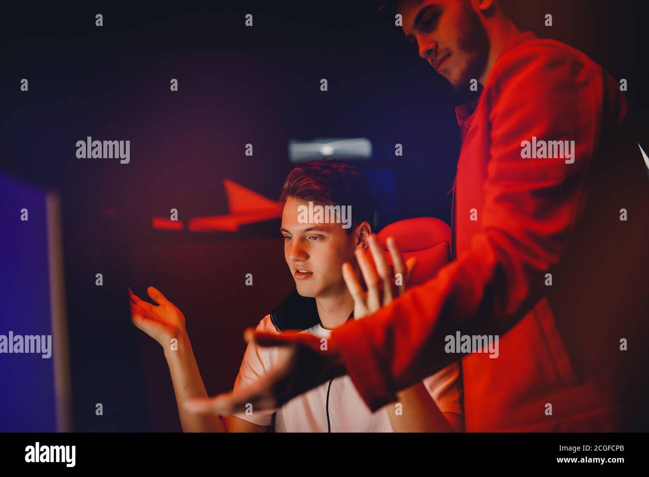 Team of two guys playing online video games analyzes strategy of ...