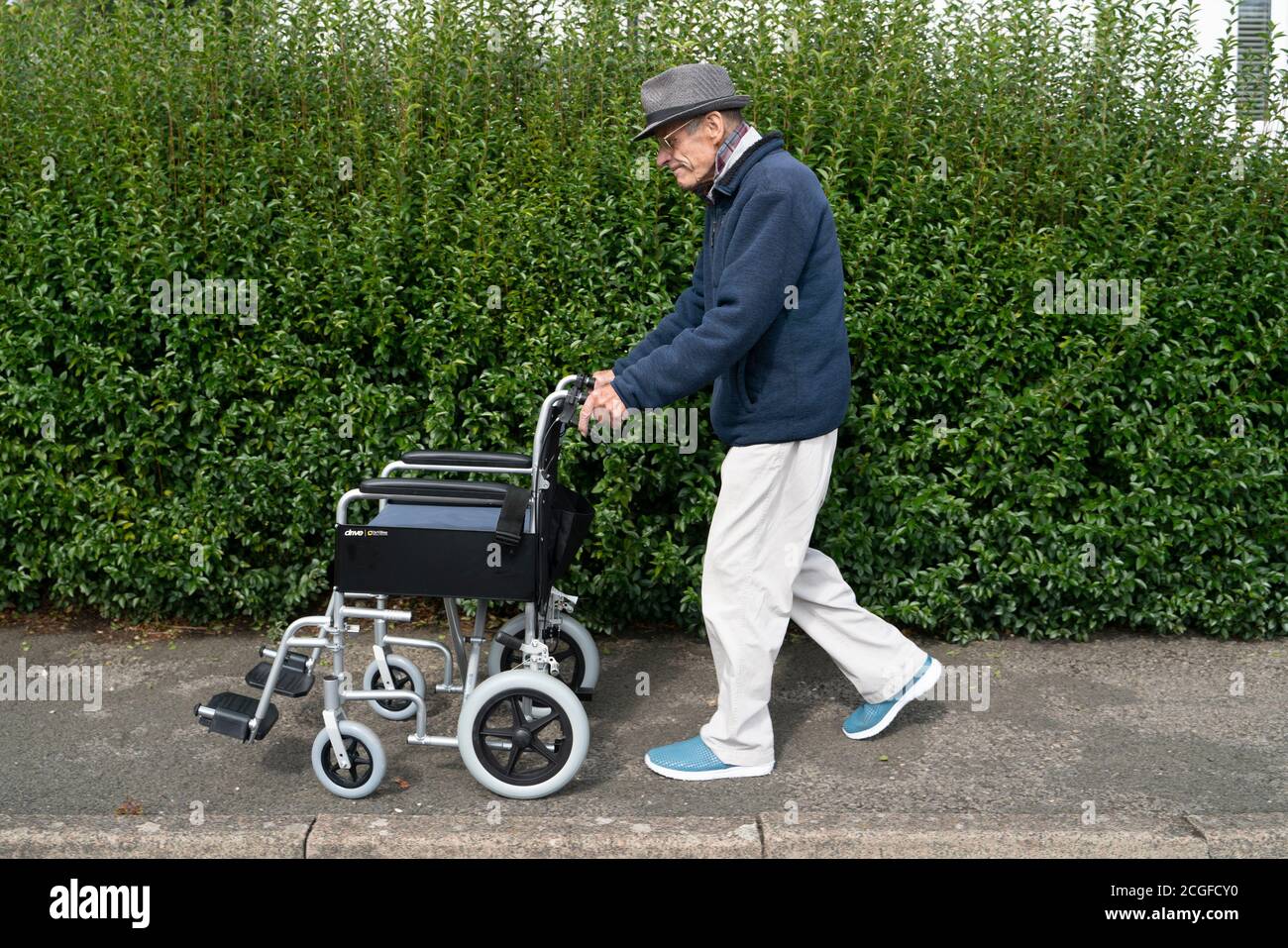 Old Man Pushing Wheelchair Stock Photo - Alamy
