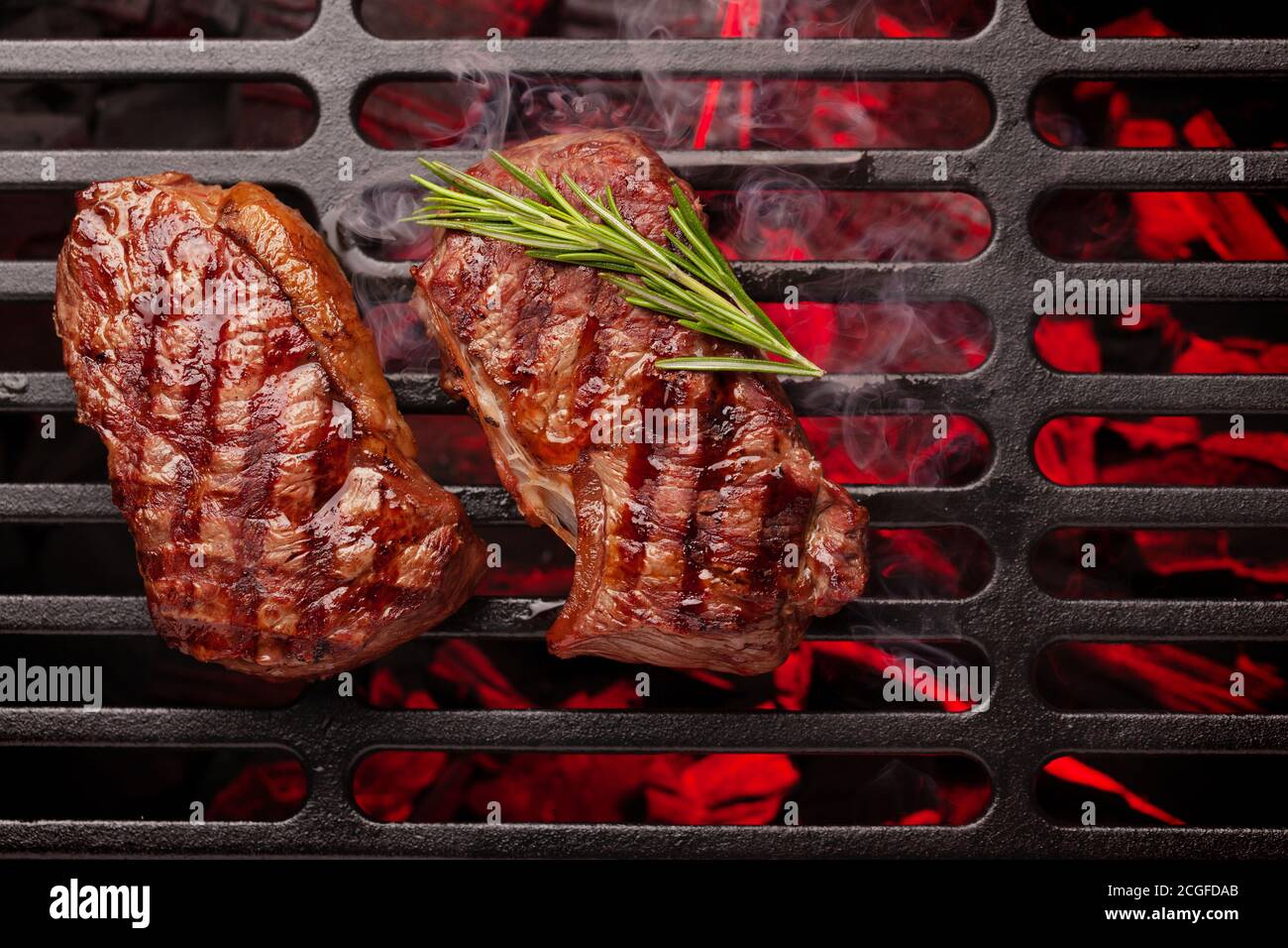 Beef steaks cooking on grill with spices and herbs. Top view flat lay ...