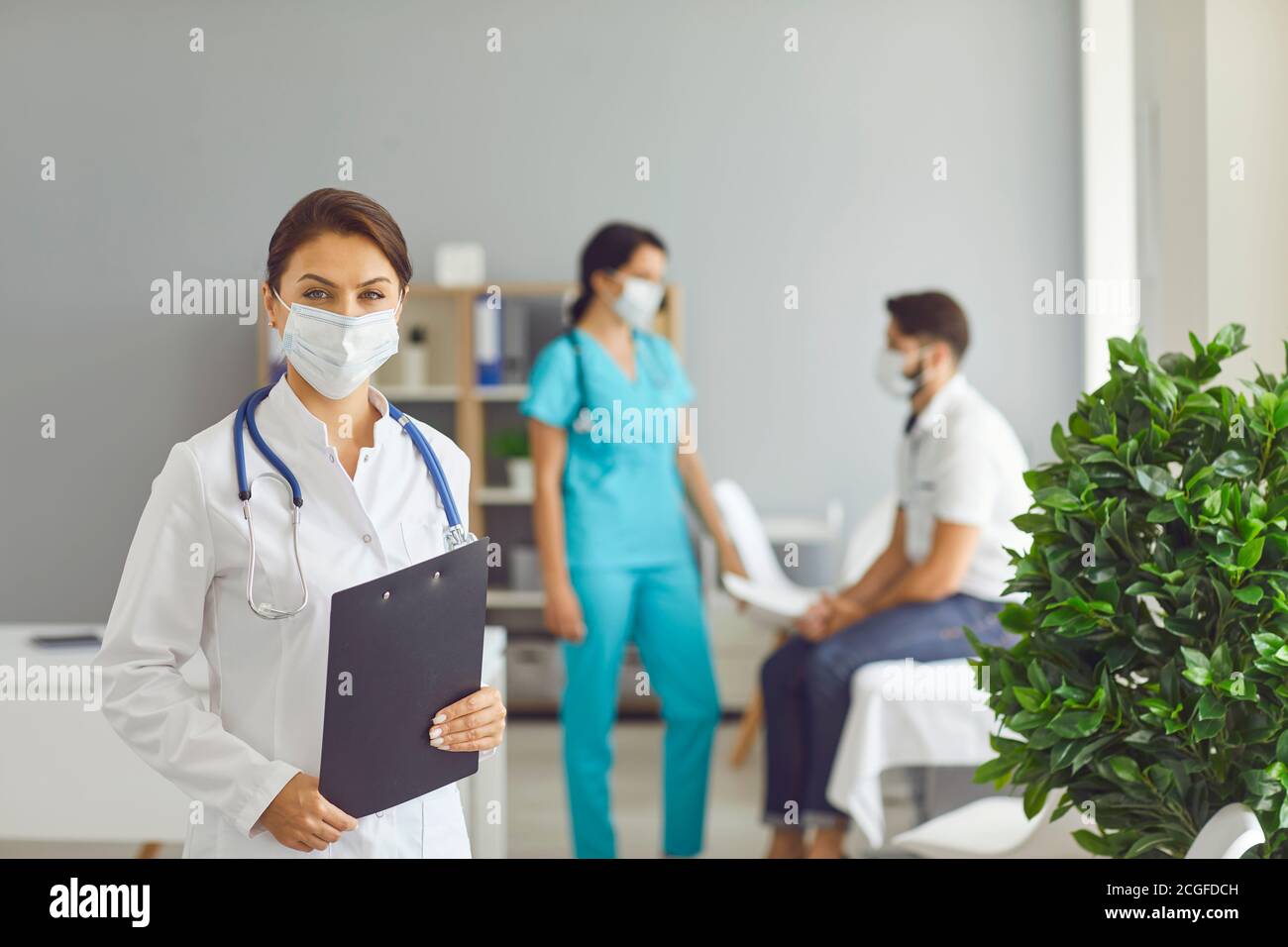 Professional female doctor on the background of a patient and a nurse ...