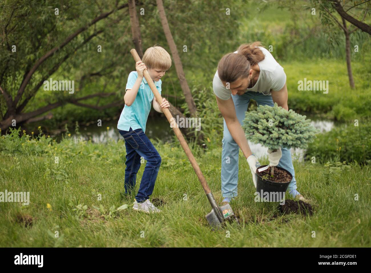 Fair-haired little daddys helper, son, kid, digging a whole together ...