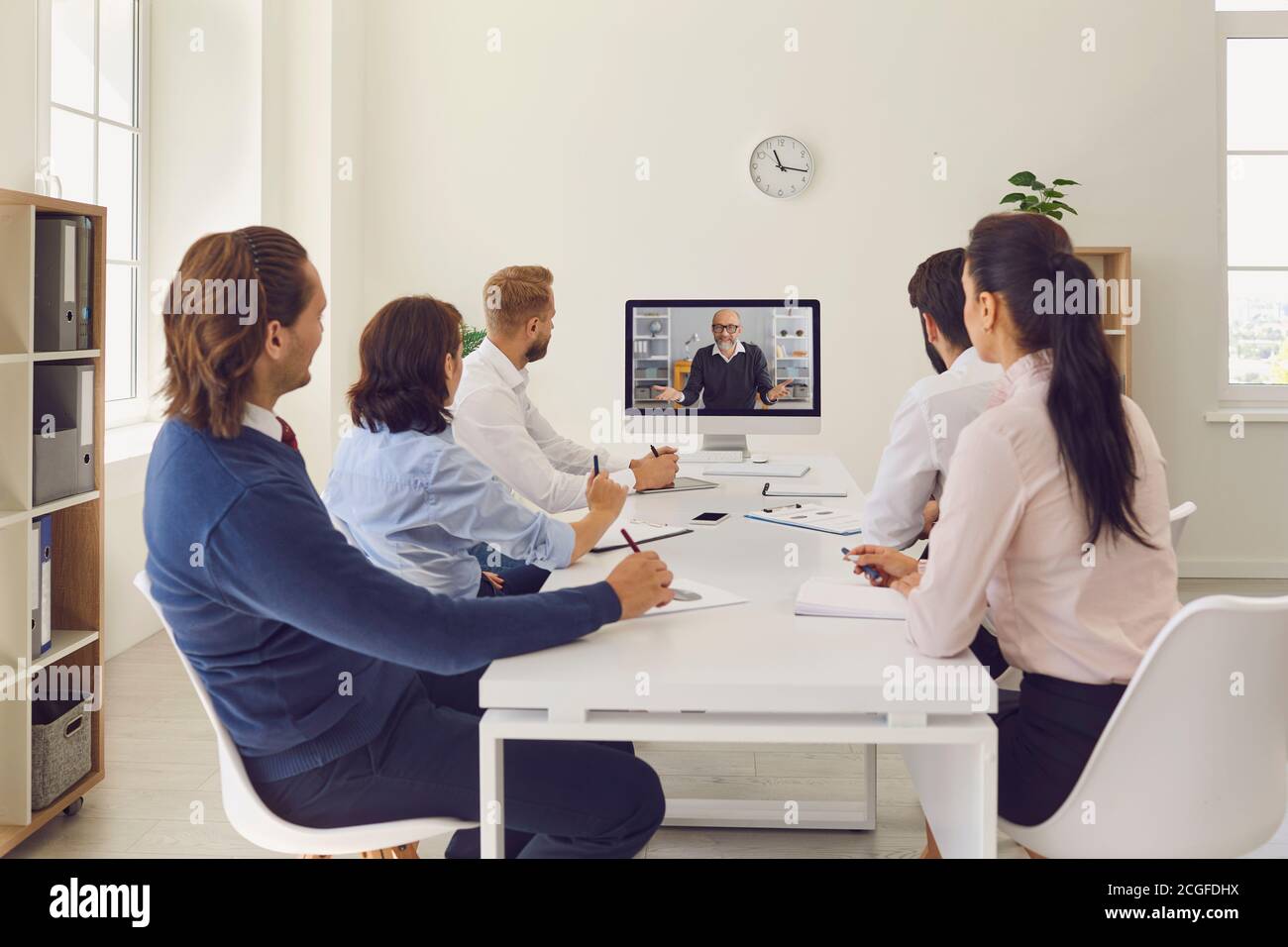 Group of business people looking and listening to talking from laptop ...