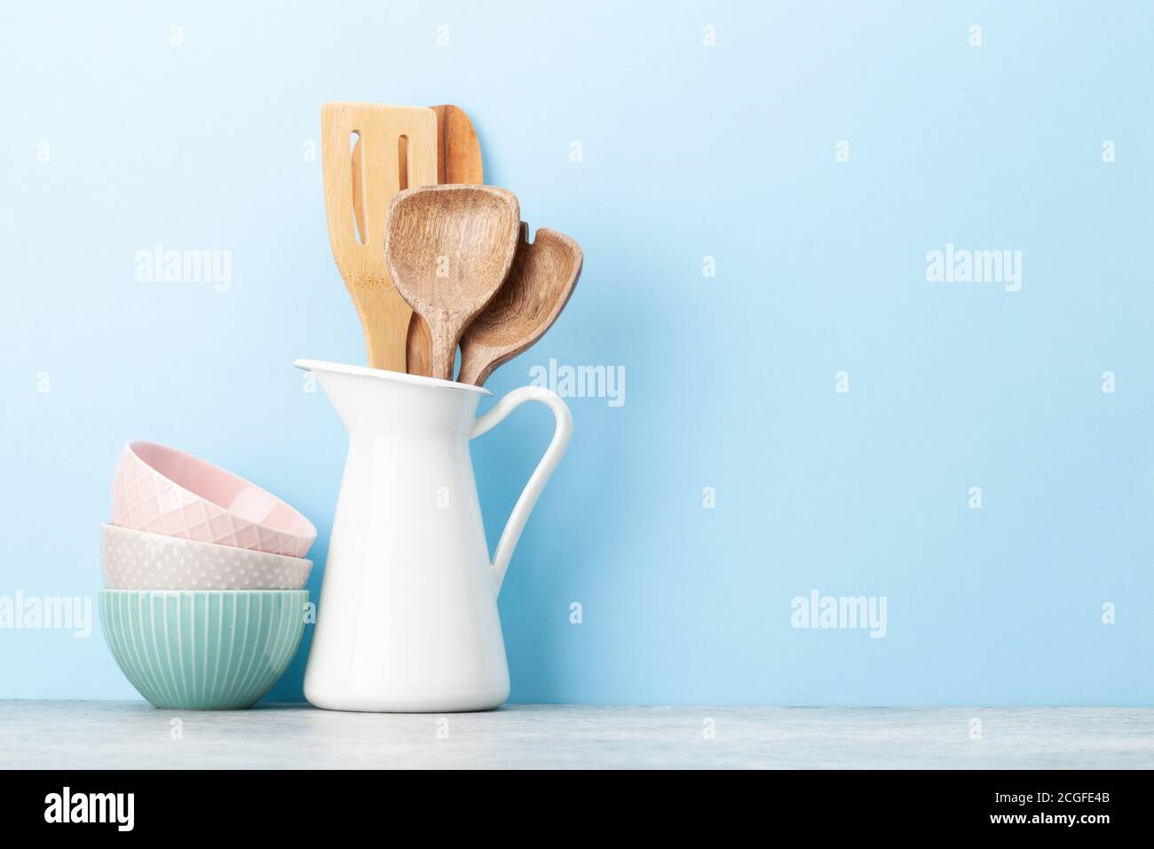 Kitchen utensils and dishes in front of blue background with copy space ...