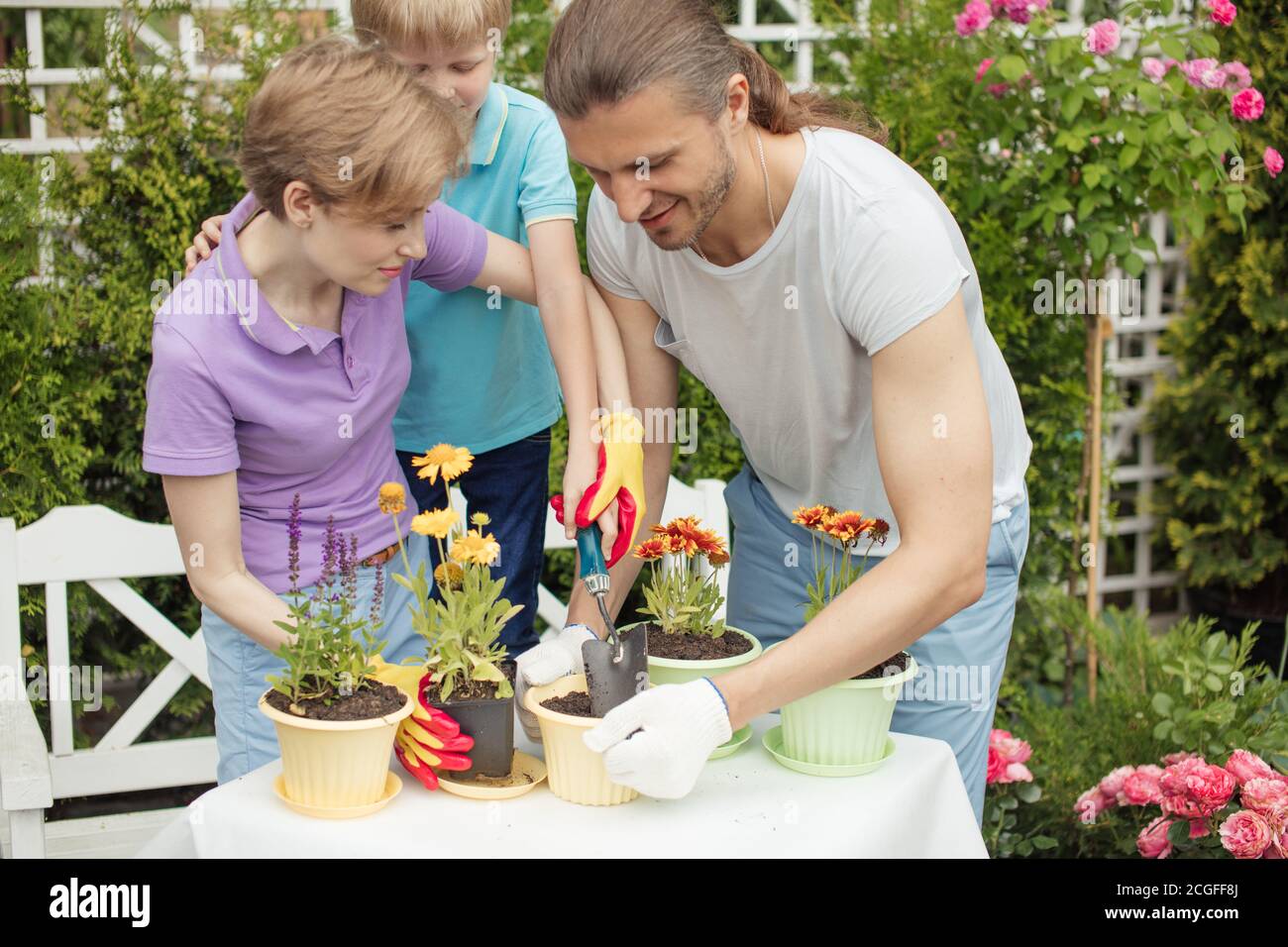 Planting flower. Gardening. Planting. Parents with son planting flower ...
