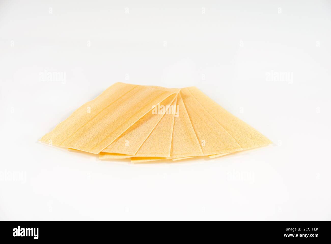 Raw sheets of lasagna pasta on a white. Pile of dried lasagna pasta ...