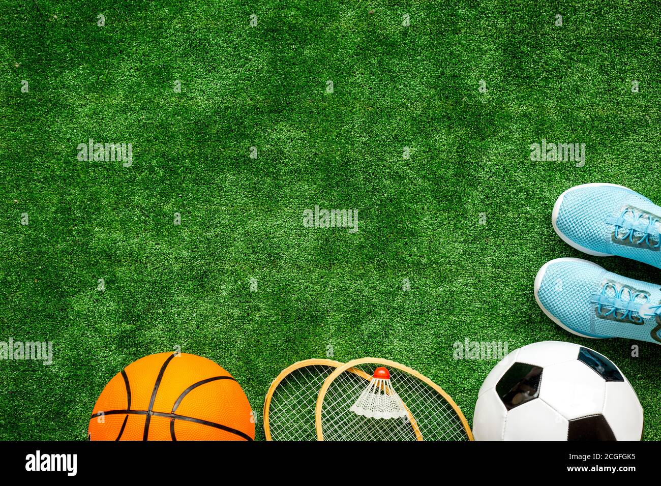 Sport balls and badminton rackets on football grass. Top view copy ...