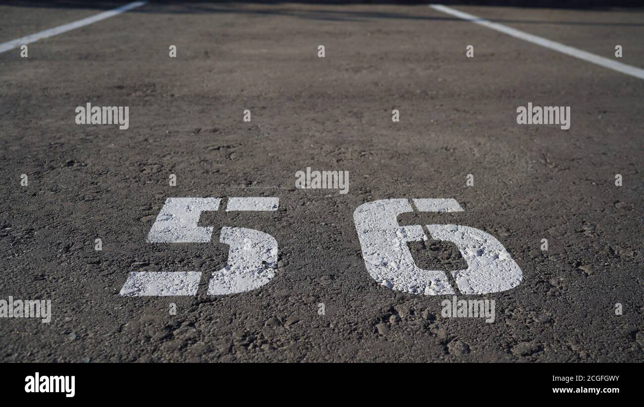 Close-up of a white paint number marking in a parking lot. Empty ...