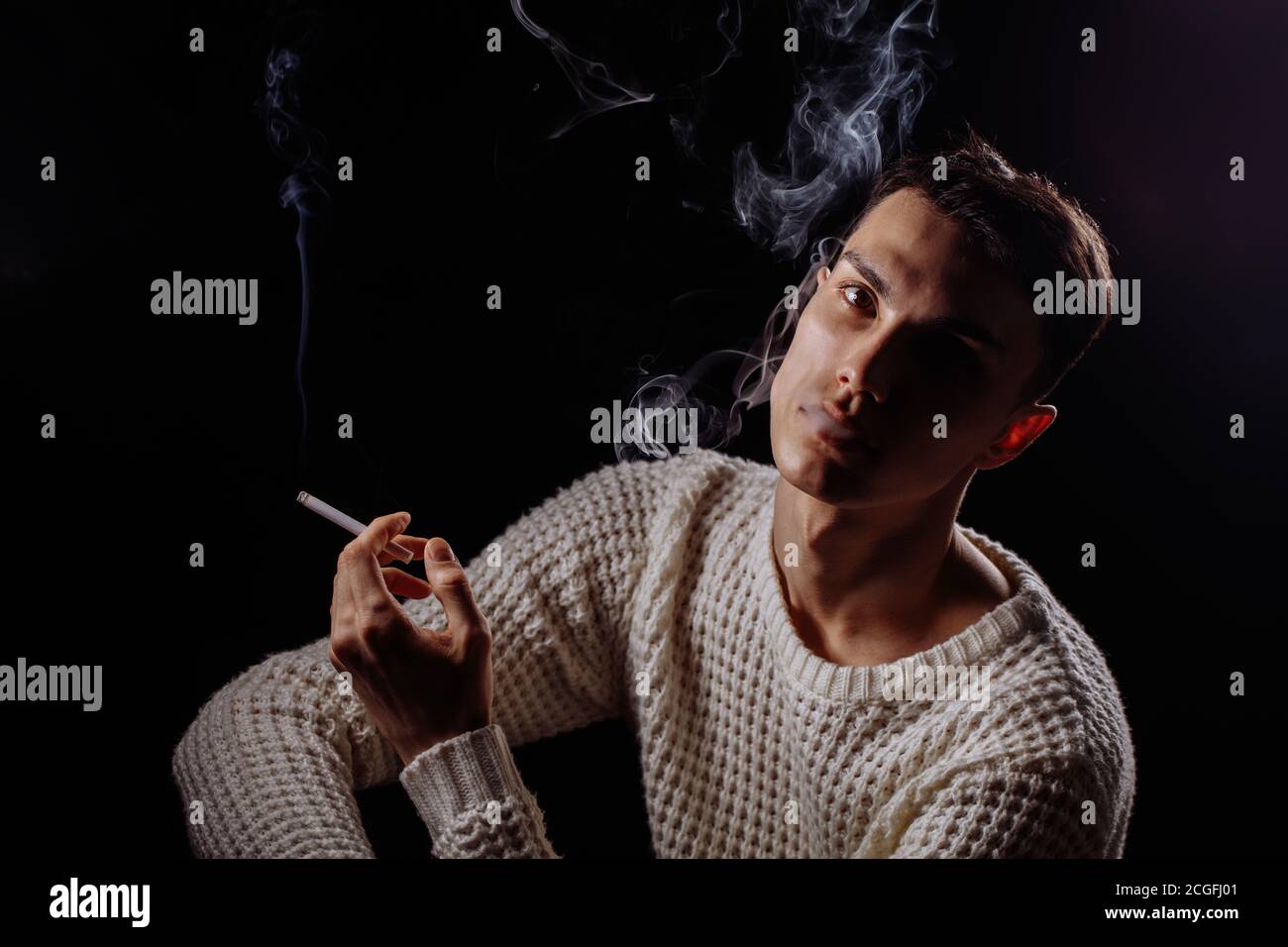 sad handsome man with cigarette on black background Stock Photo - Alamy