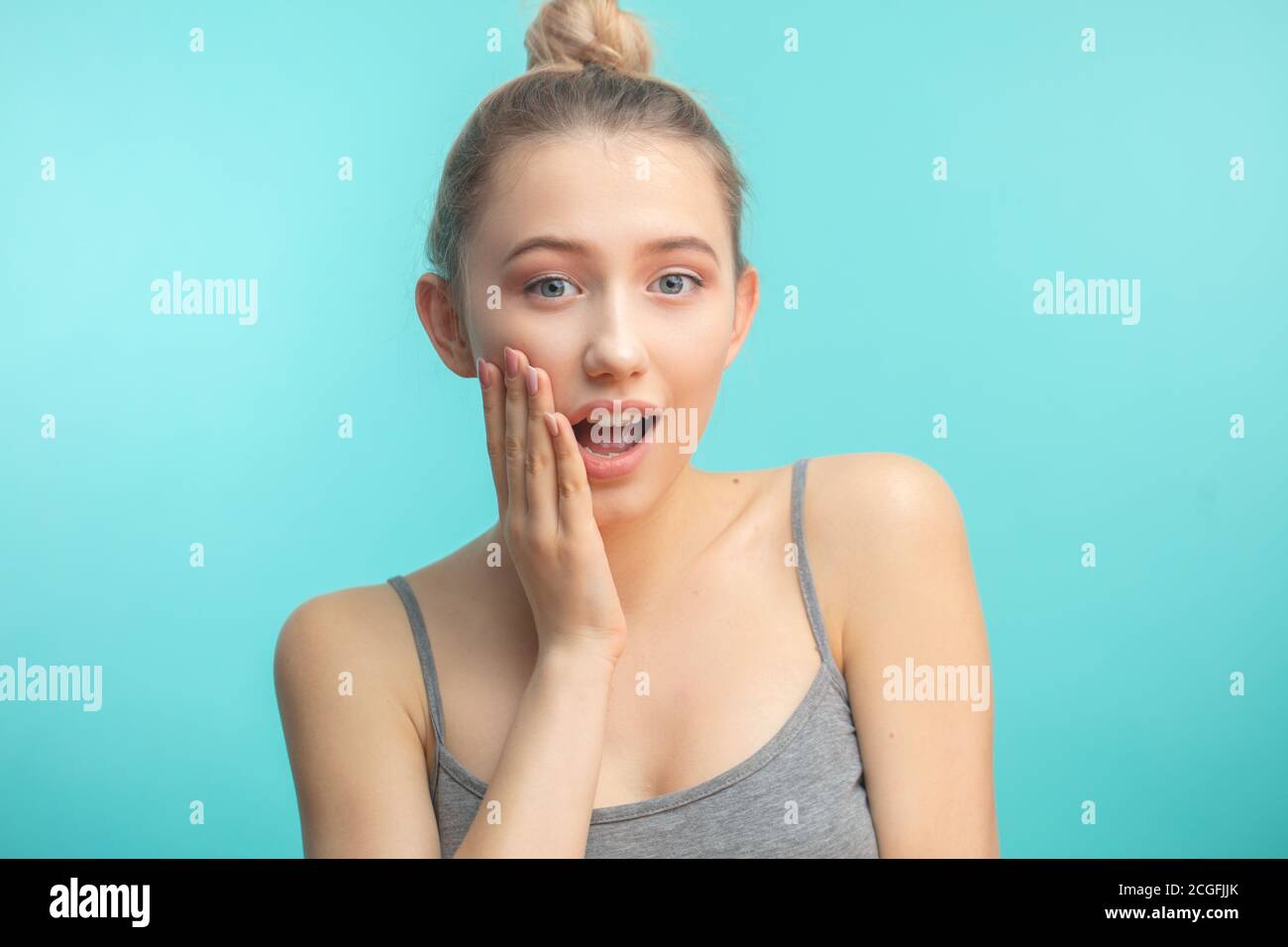 Isolated studio shot of young attractive woman with hair knot staring ...