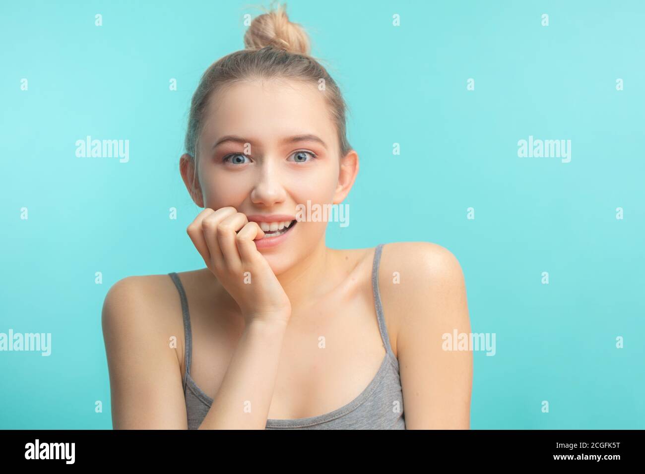 Isolated studio shot of young attractive woman with hair knot staring ...