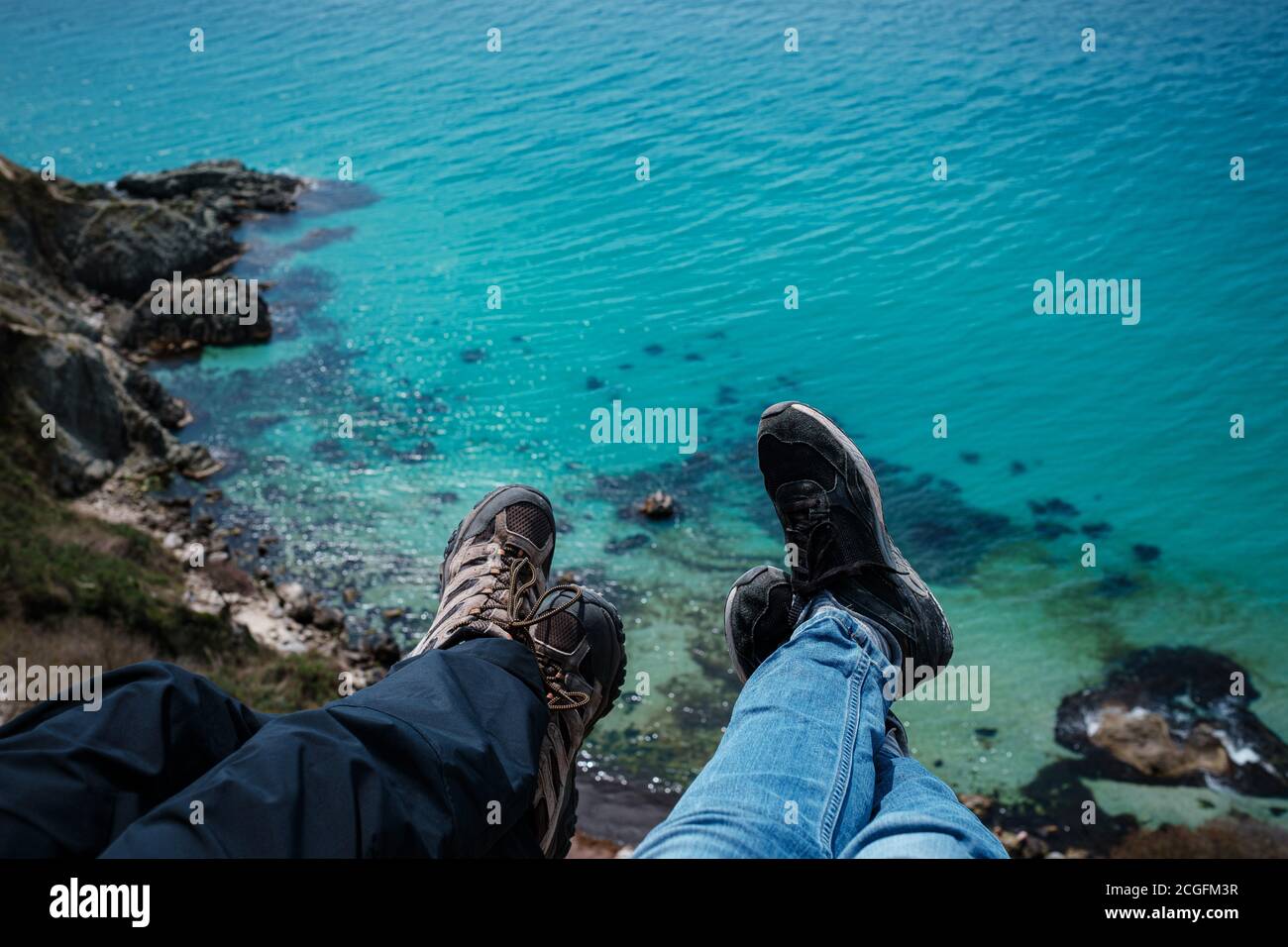 Hipsters legs in sneakers on a sea cliff above blue ocean Stock Photo ...