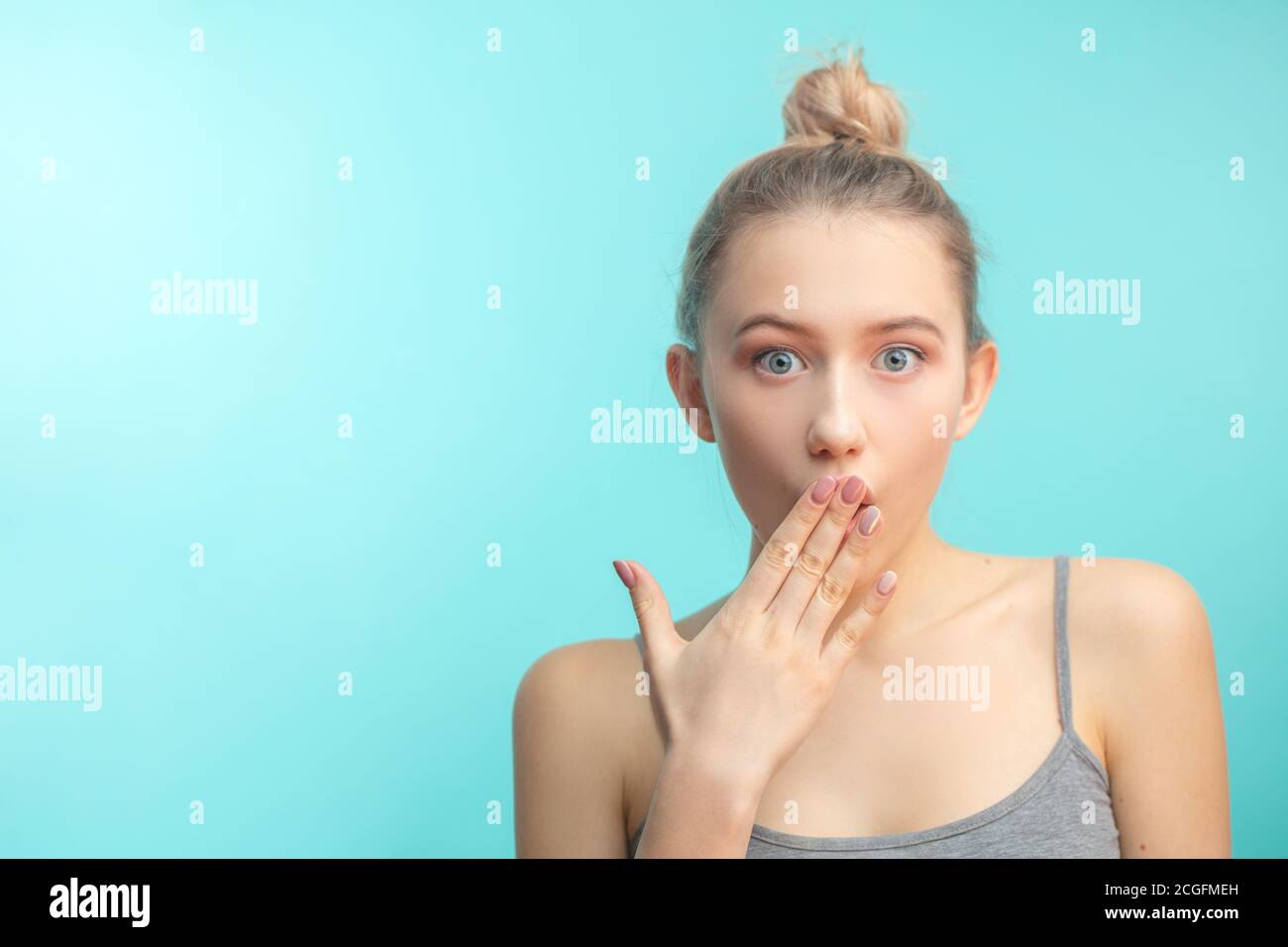 Isolated studio shot of young attractive woman with hair knot staring ...